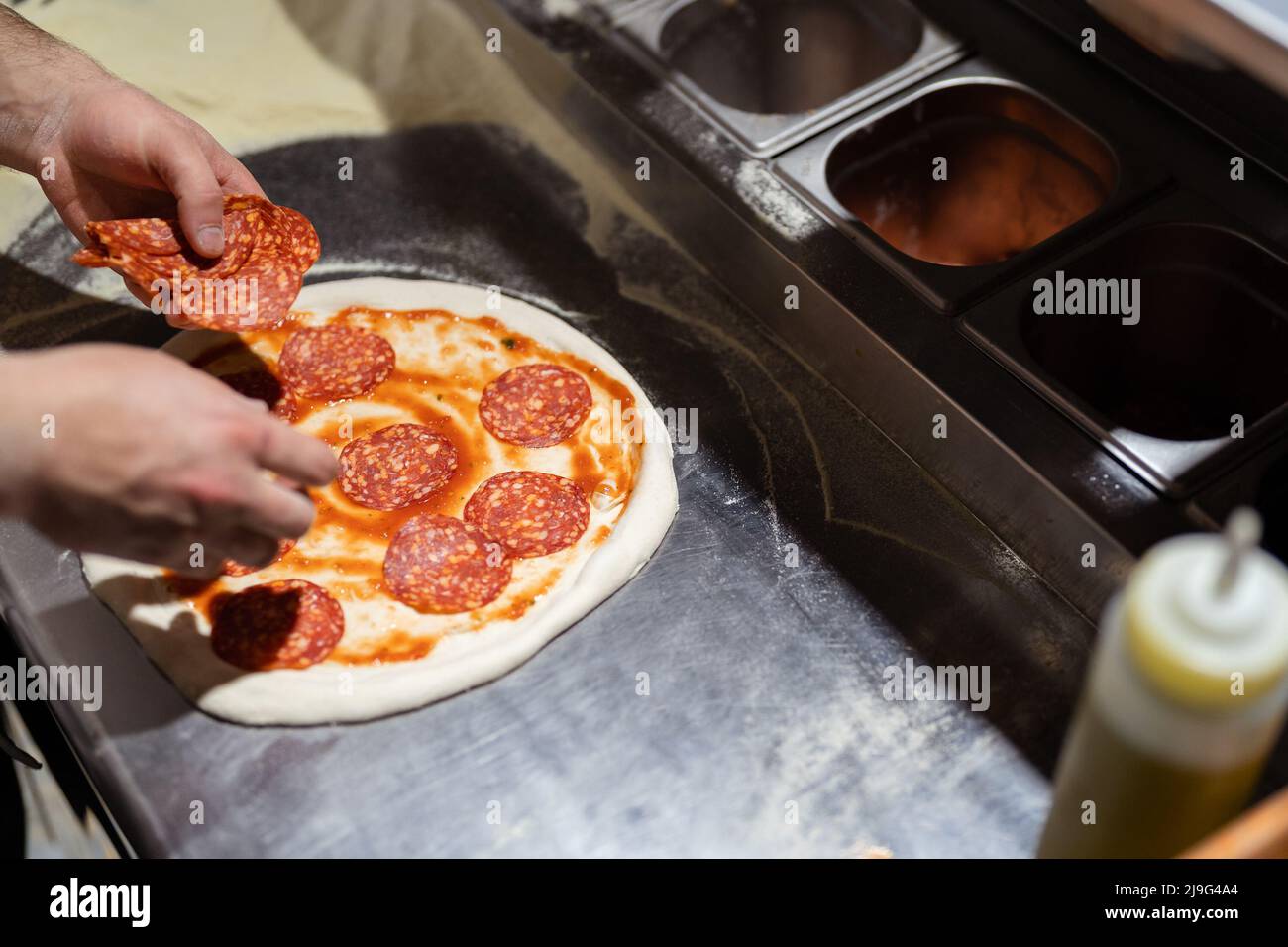 Pizza making process. Male chef hands making authentic pizza in the ...