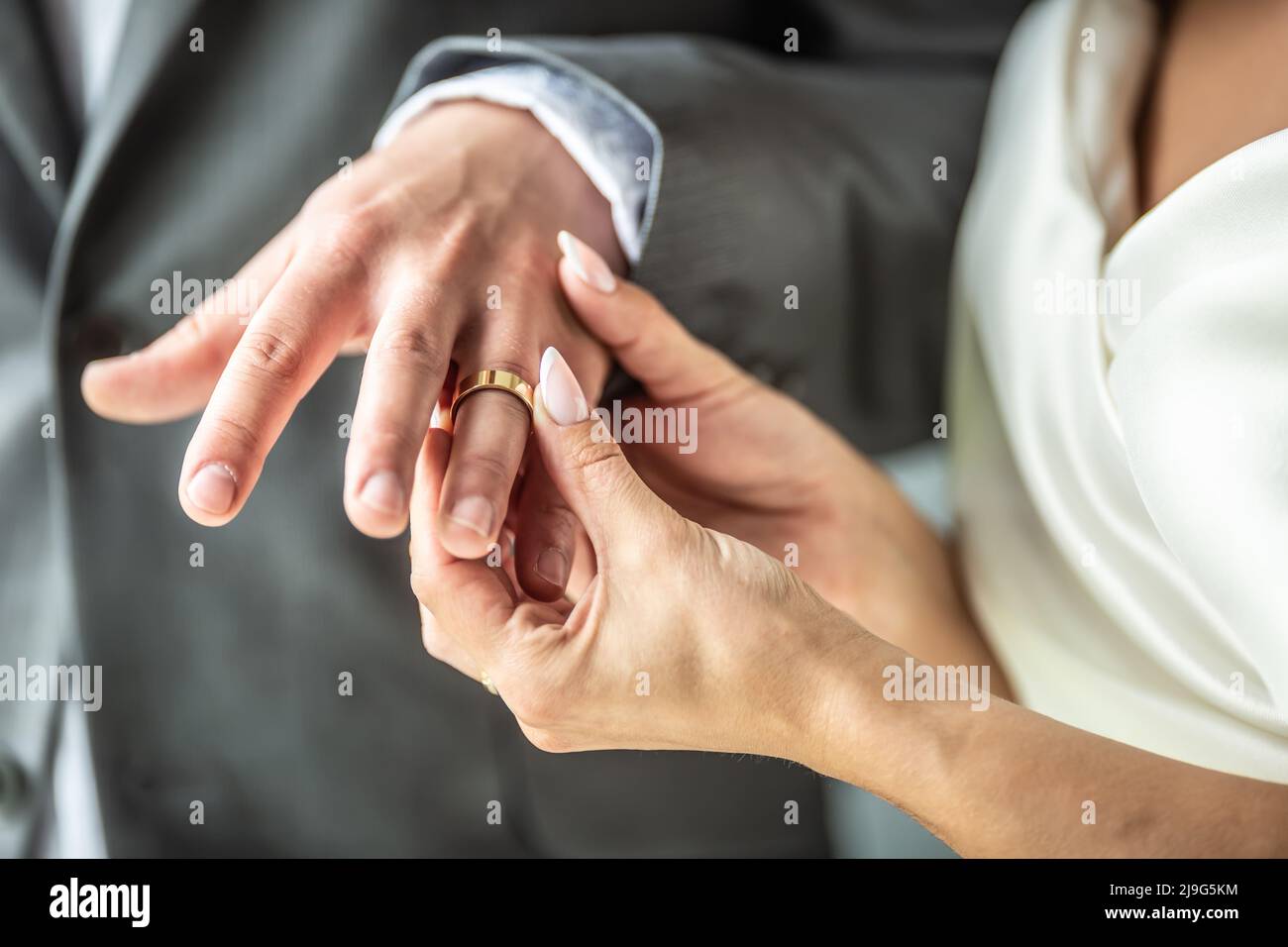 Putting wedding ring on finger during wedding ceremony hi-res stock ...