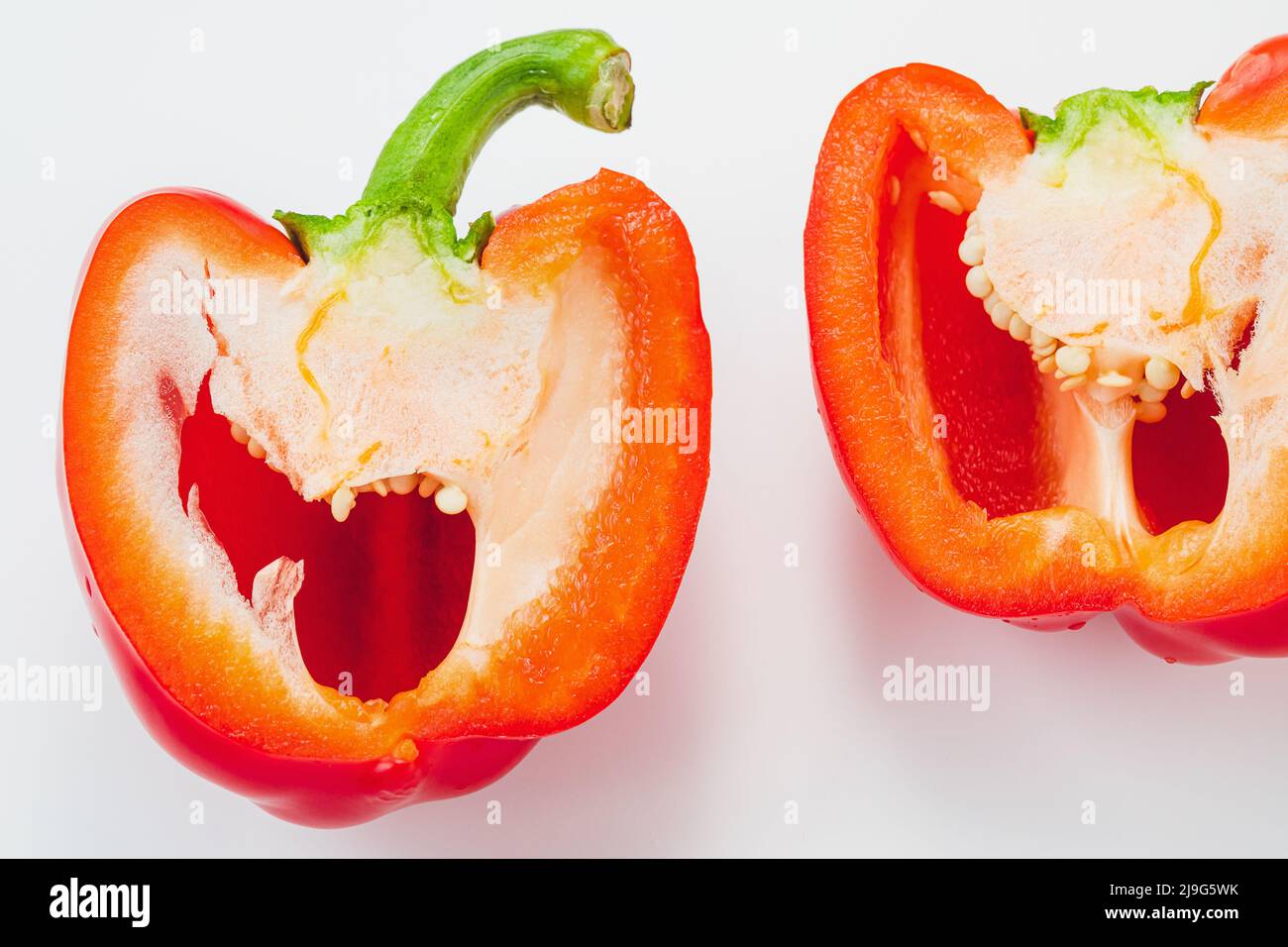 Fresh ripe sweet red bell pepper cut in half on white background ...
