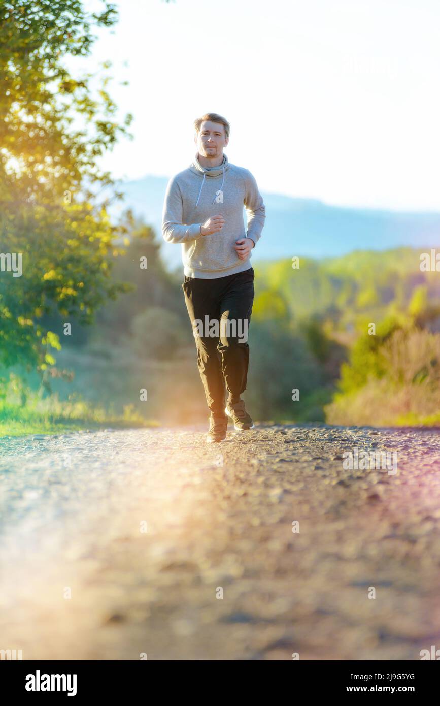 Running man jogging in rural nature at beautiful summer day. Sport ...