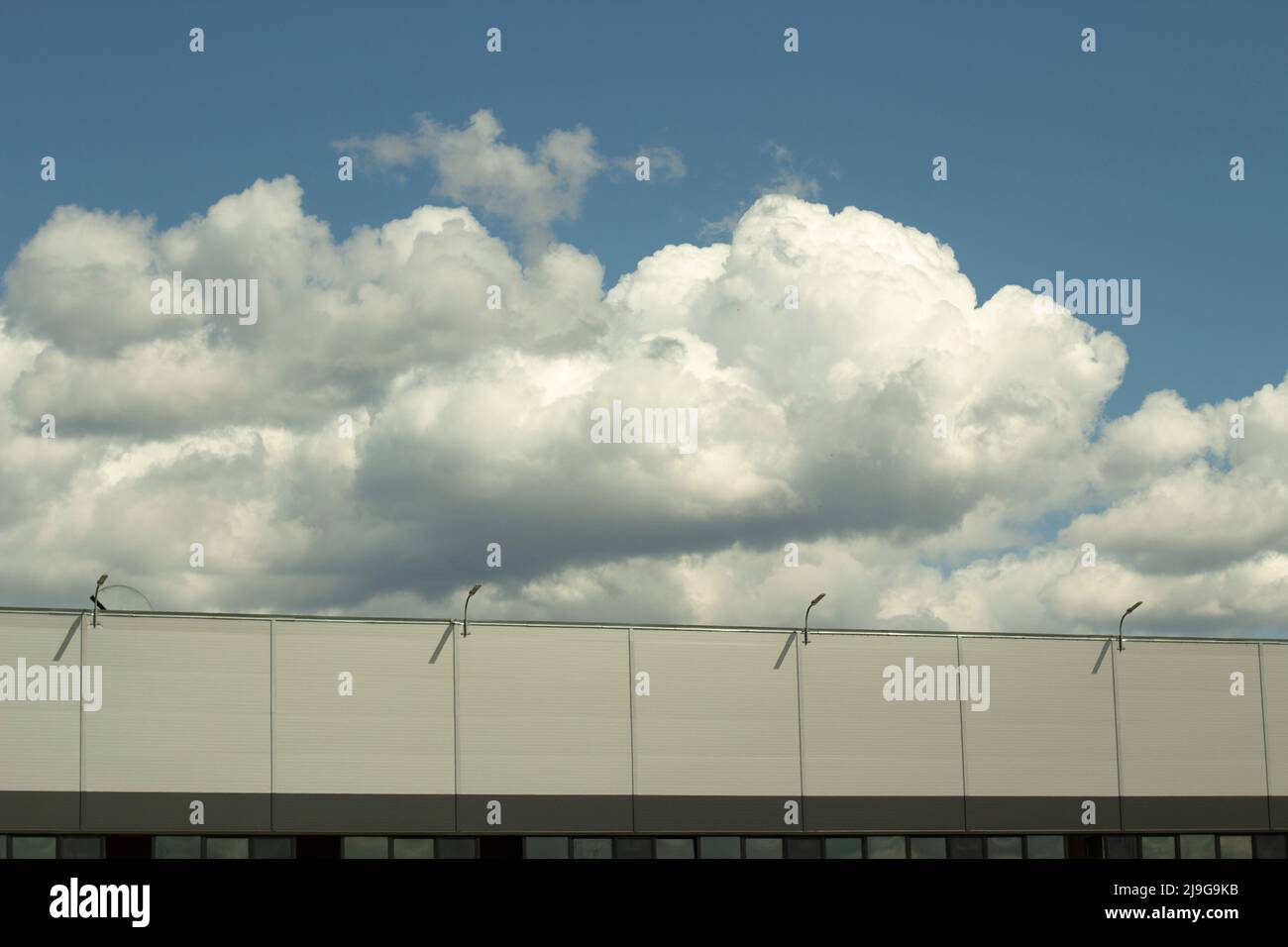 Warehouse and sky. Grey building. Clouds over the warehouse. Modern ...