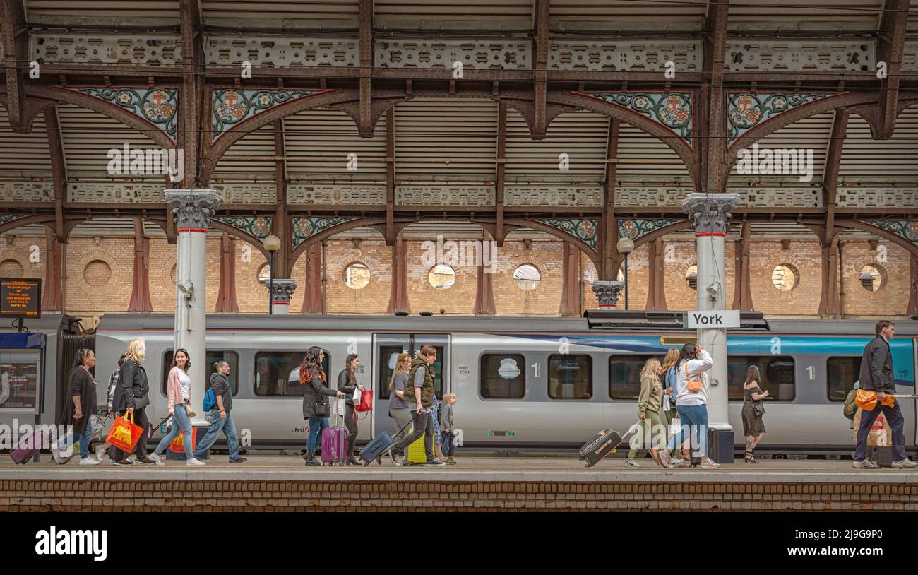 A number of passengers on a railway station platform leaving a train ...