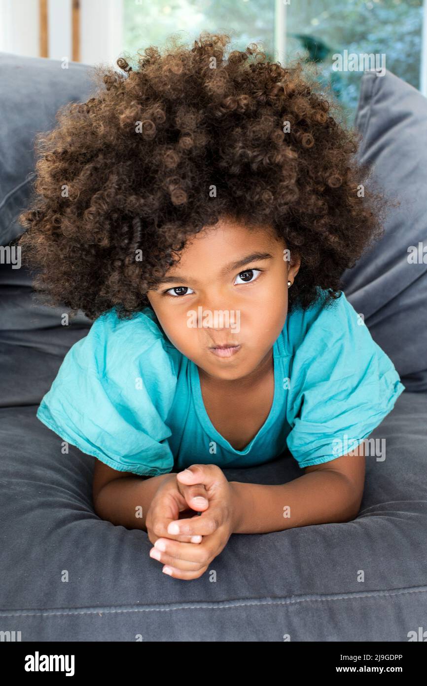 Angry girl lying on sofa Stock Photo - Alamy
