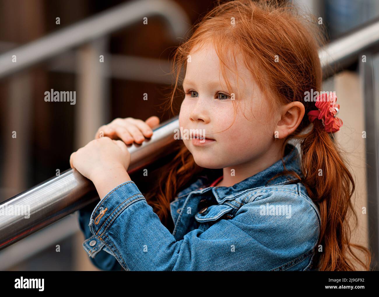 smiling red hair girl in jeans costume trying to talking on the phone ...