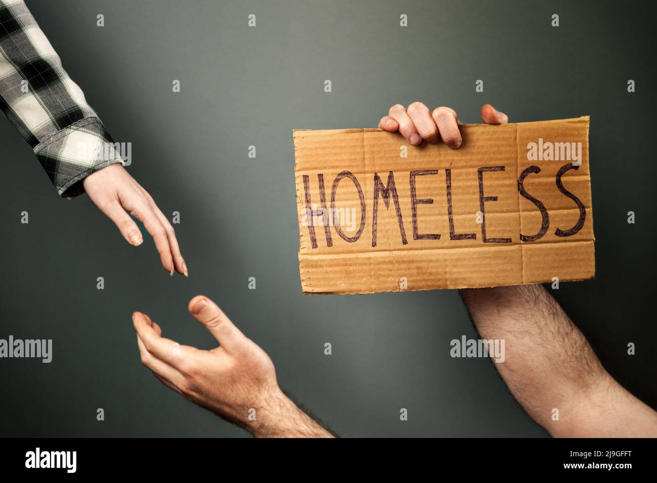 A woman extends a helping hand to a man holding a cardboard box with ...