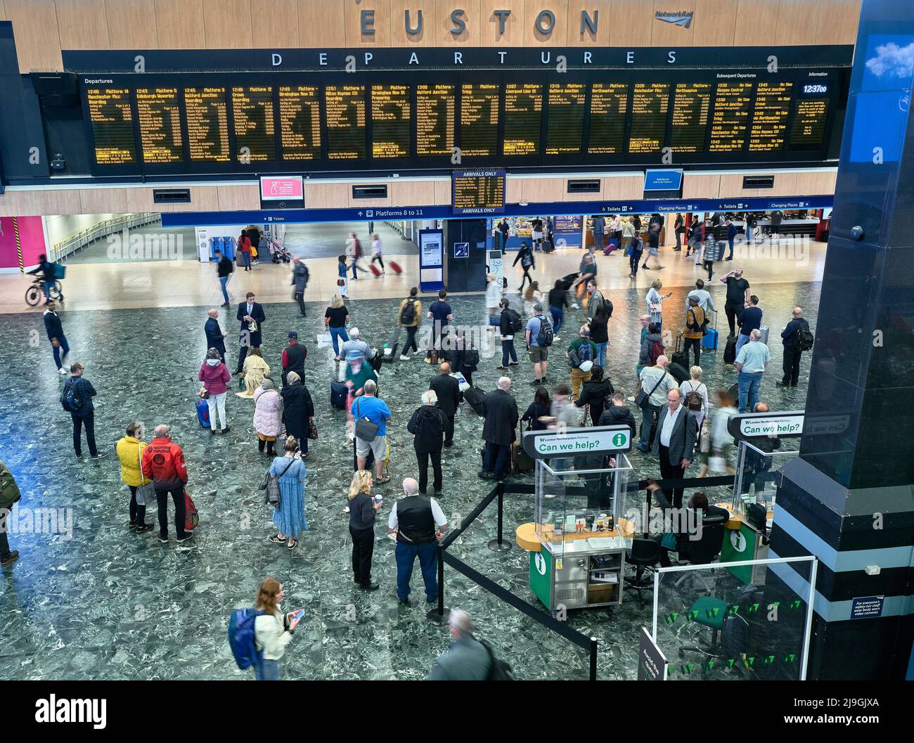 Passengers look at the train timetable board in the concourse at ...