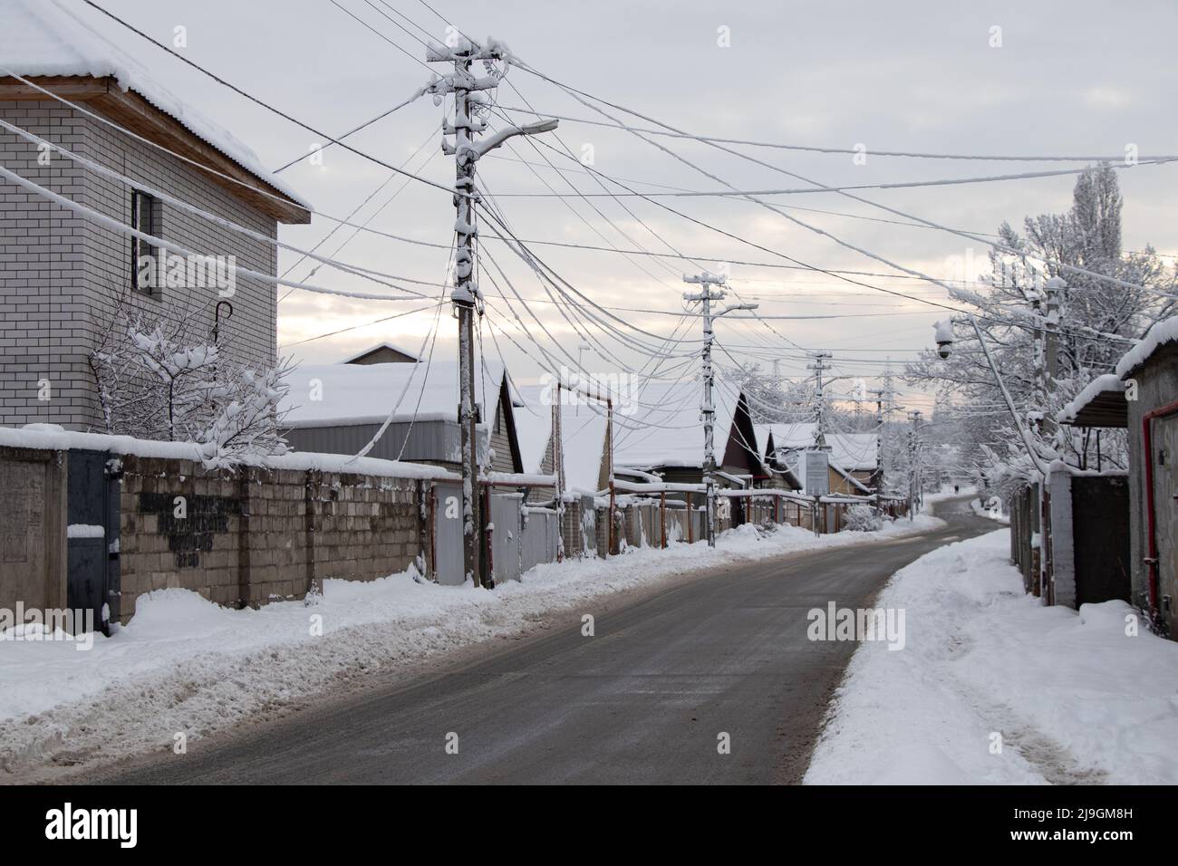 Electric wires in the snow with ice on a pole in a residential area of ...