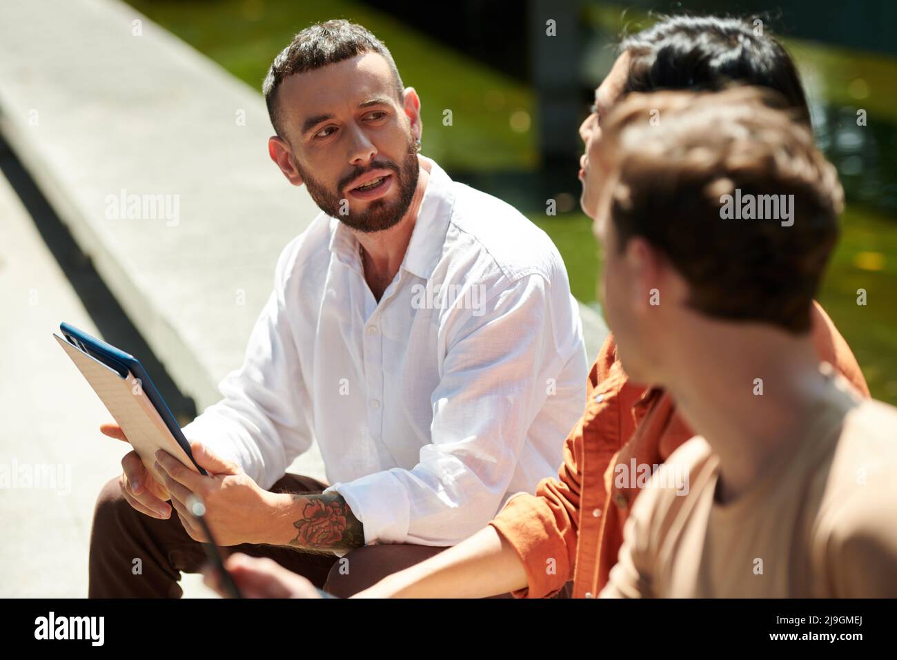 Young businessman in white shirt holding tablet computer when talking ...