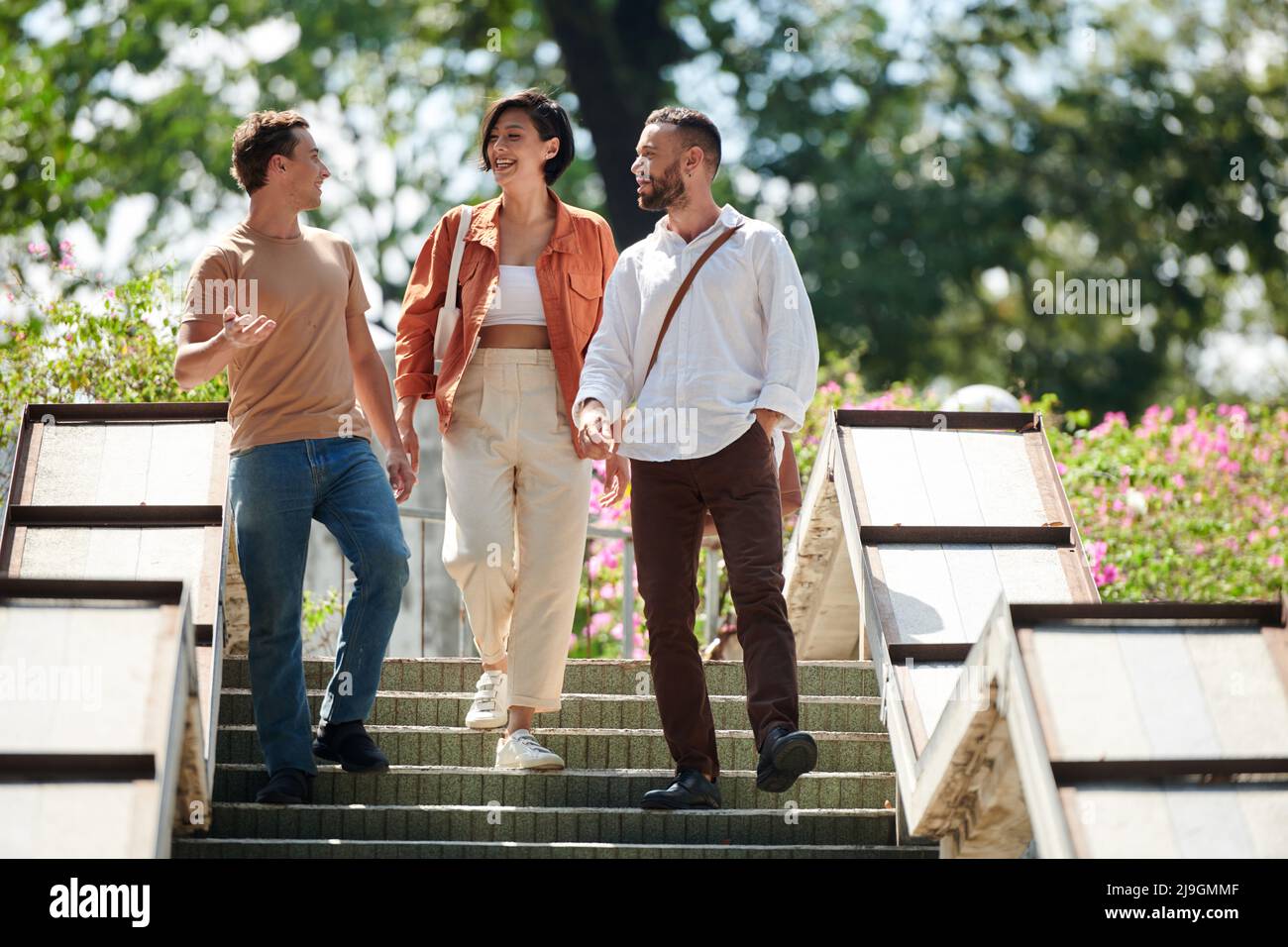 Happy group of friends talking when walking down stairs outdoors Stock ...
