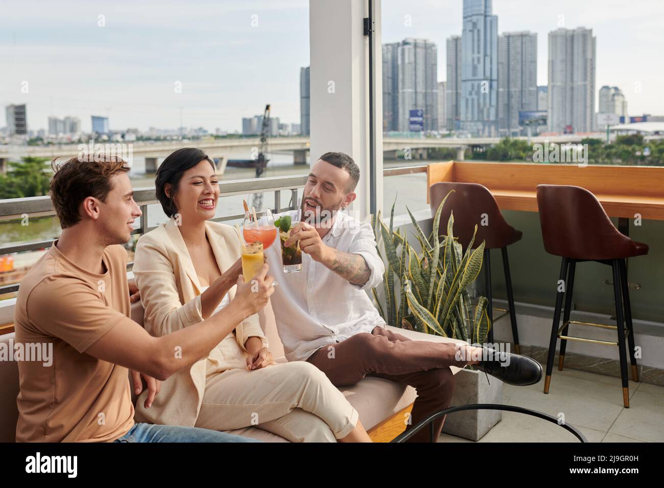Startuppers enjoying cold drinks at rooftop bar when celebrating ...