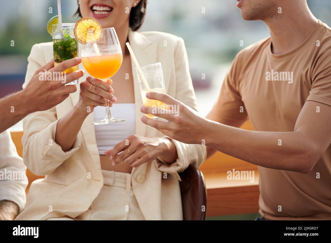 Positive colleagues enjoying drinks at rooftop party after work Stock ...