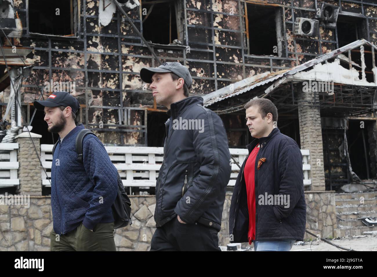 Mariupol. 22nd May, 2022. Local residents pass by a damaged building at ...