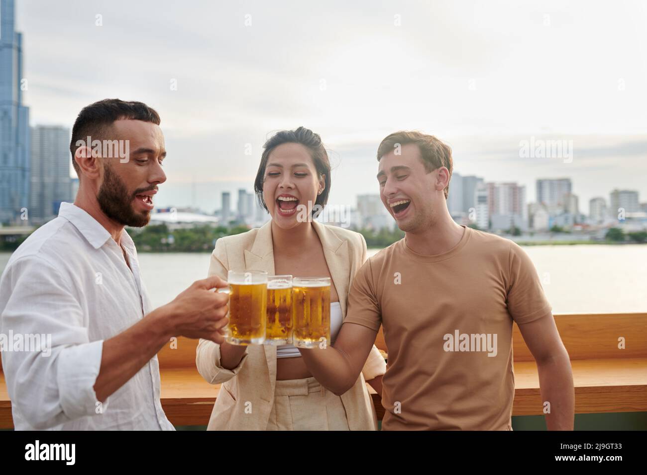 Group of young people having fun hanging out and drinking beer at ...