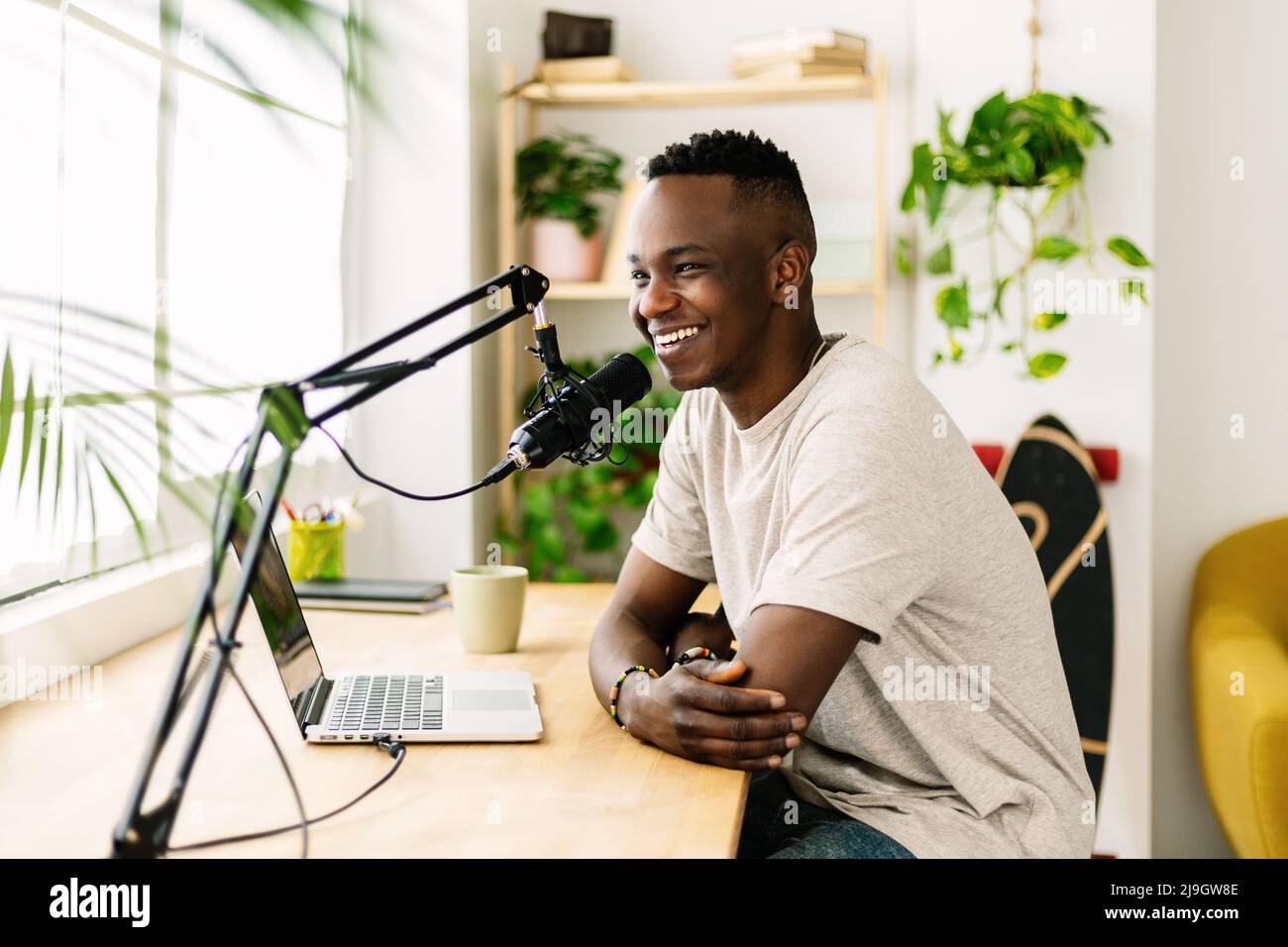 Happy young african man making audio podcast from home studio Stock ...