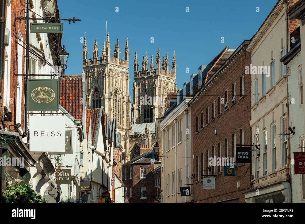 Morning on Low Petergate in York old town, England. York Minster towers ...