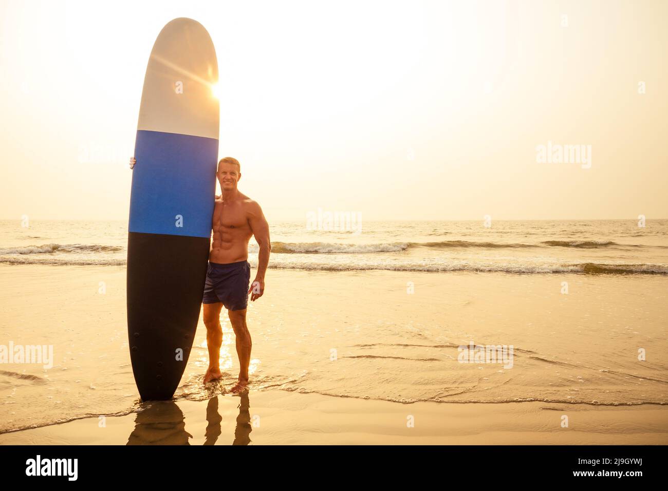 surfing freelancing man is standing with a surf in his hands on the sea ...