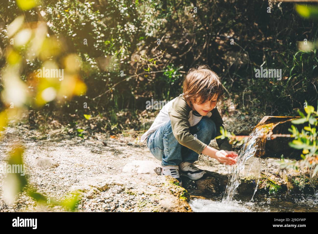 School boy kid drinking water from the mountain creek. Tourist child ...