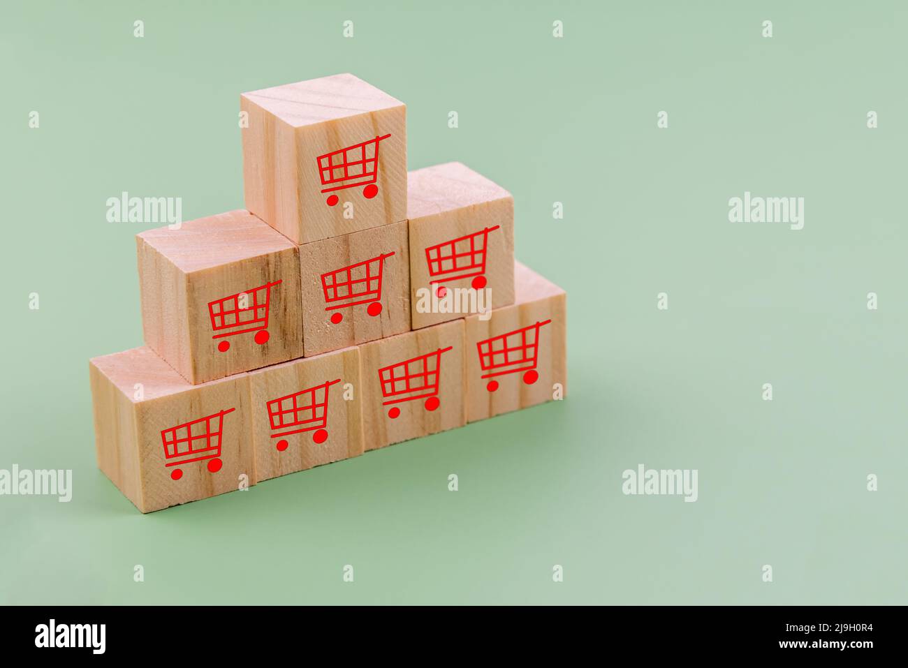 Shopping cart icon on wood block on green background Stock Photo - Alamy