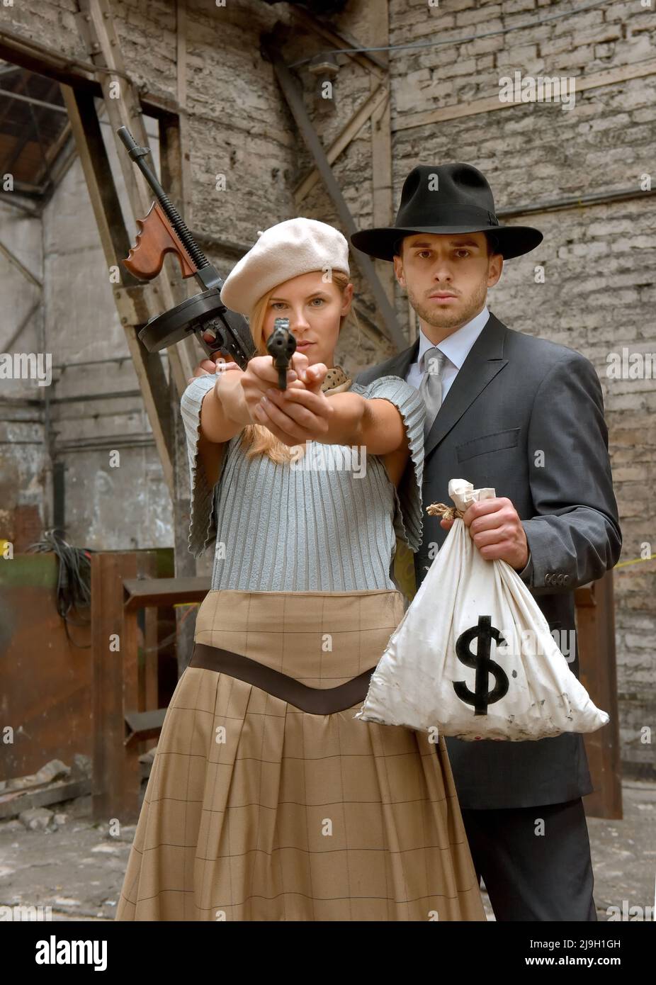 A young couple get dressed up in 1930 style clothing. They each carry a ...