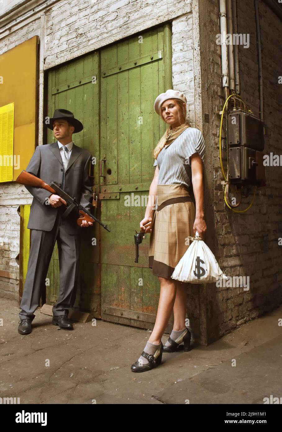 A young couple get dressed up in 1930 style clothing. They each carry a ...