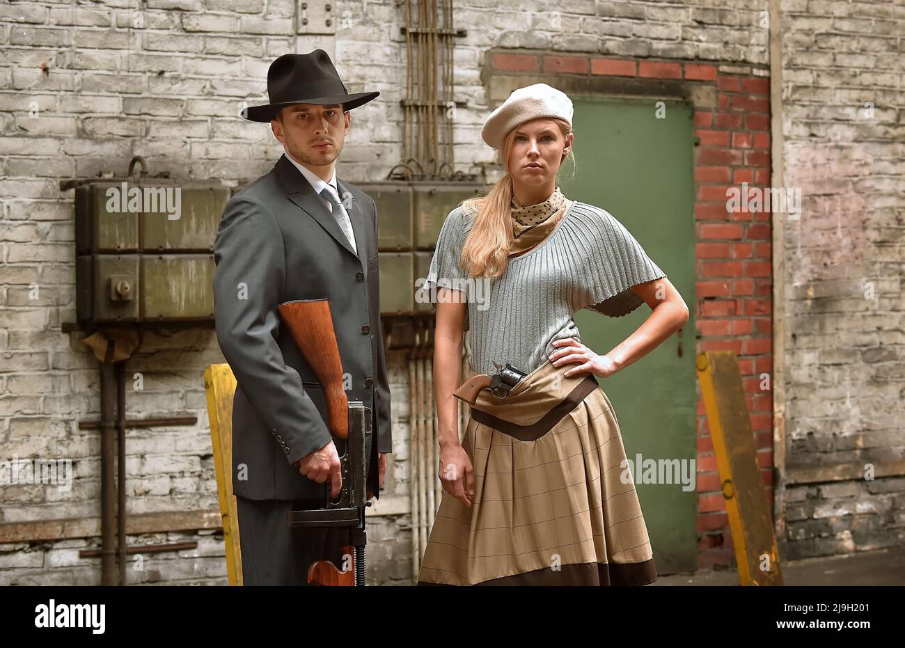 A young couple get dressed up in 1930 style clothing. They each carry a ...