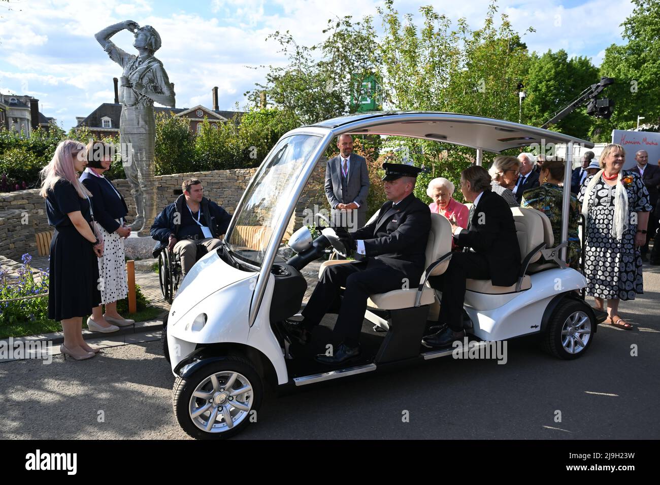 Queen Elizabeth II sitting in a buggy during a visit by members of the ...