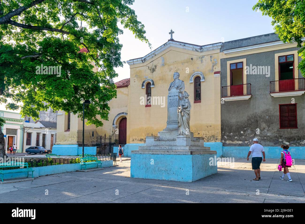 Cuban people walk by an old sculpture of Manuel de Jesus Doval in a ...