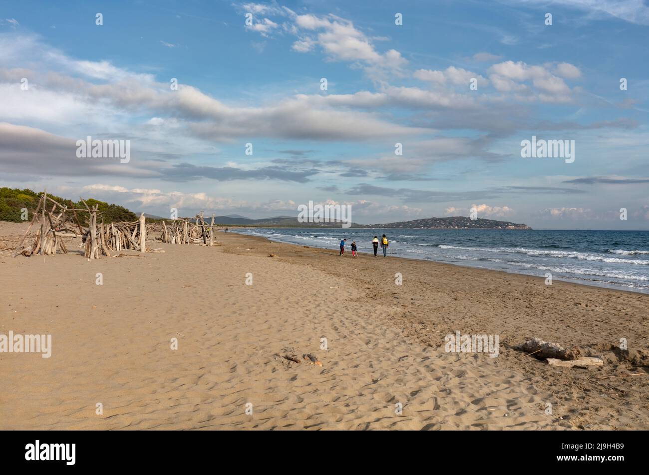 People walk on Feniglia beach on Southern tombolo linking mainland and Monte Argentario ...