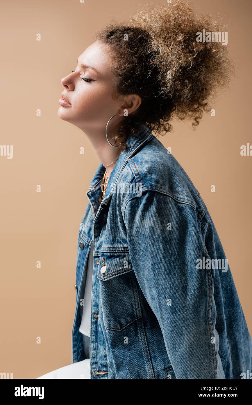 Young model in denim jacket and accessories isolated on beige Stock ...