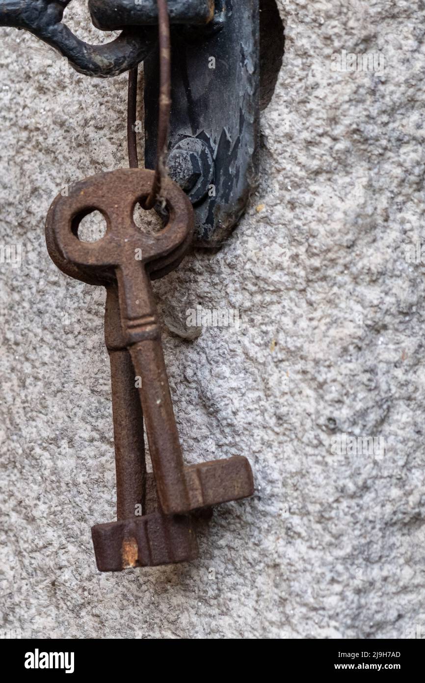 Antique iron keys hung on a granite wall Stock Photo - Alamy