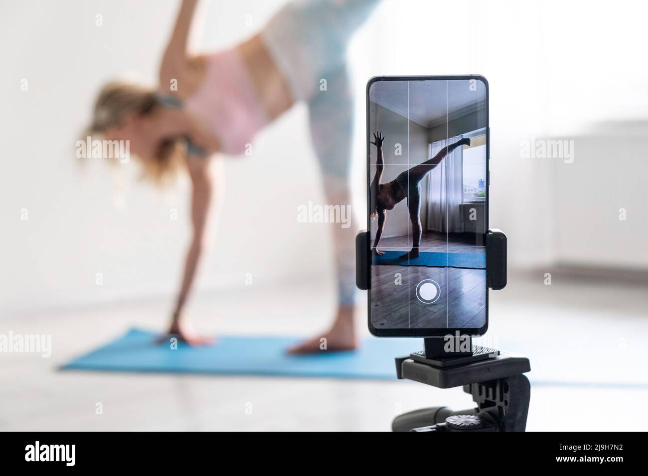 woman practicing yoga poses stretching in front of phone camera sport ...