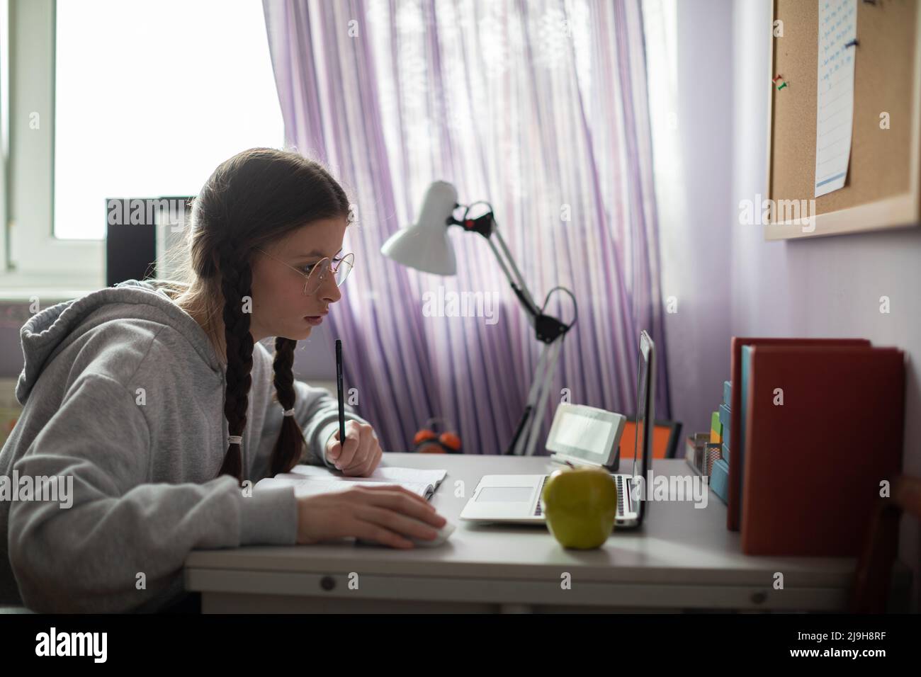 The teen is studying remotely via the internet using a laptop Stock ...