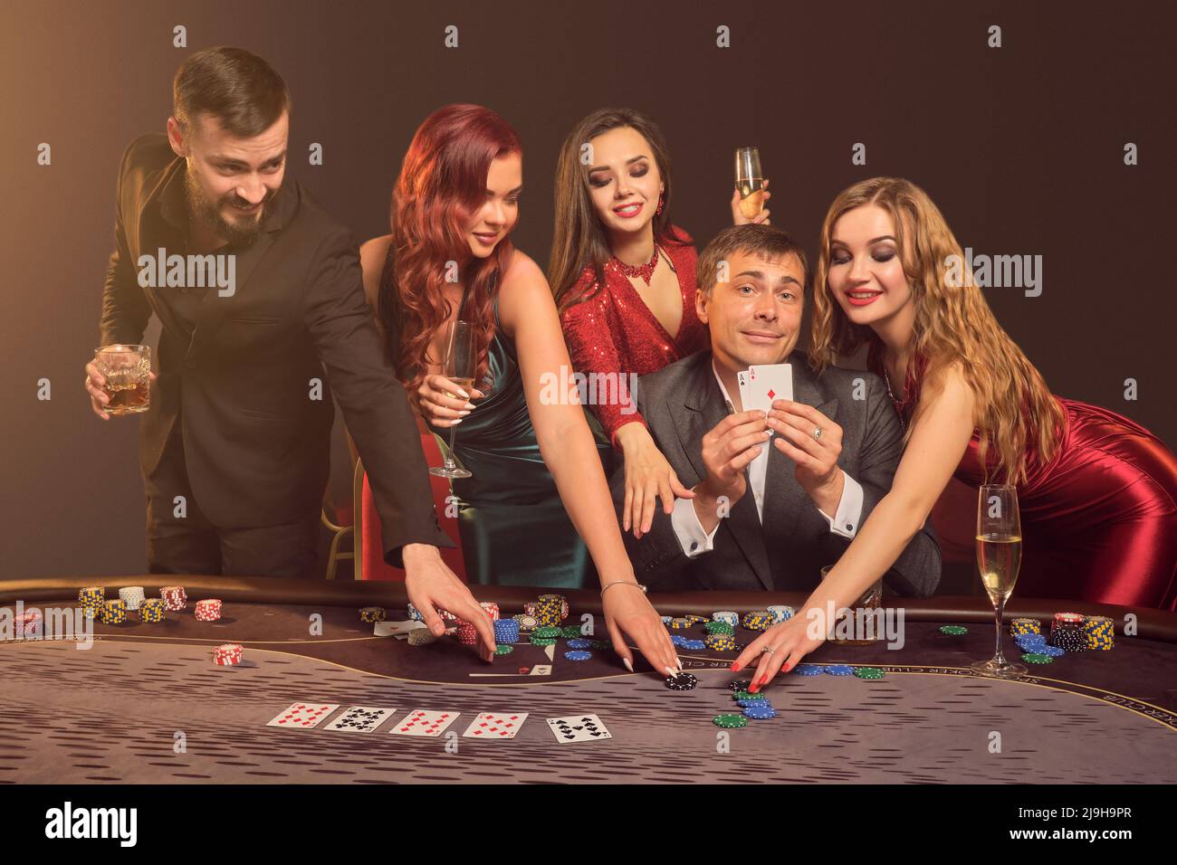Group of a young wealthy friends are playing poker at a casino Stock ...
