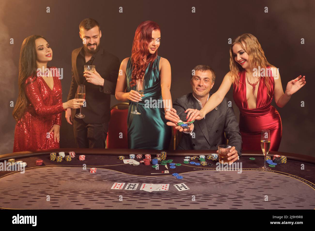 Group of a young wealthy friends are playing poker at a casino Stock ...