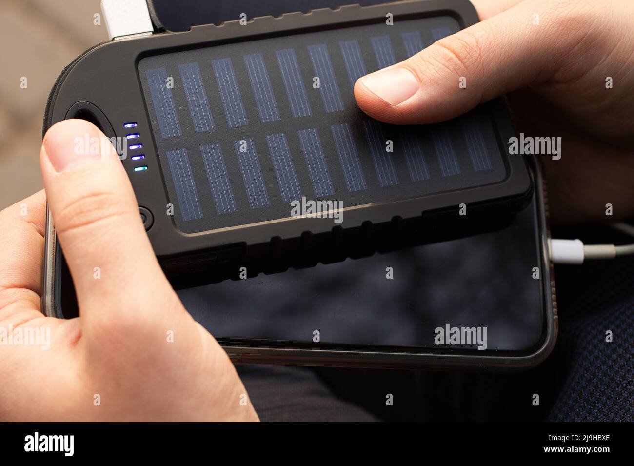 Closeup photography of man's hand,holding powerbank with solar battery ...