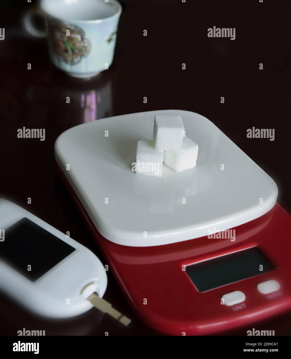 Sugar cubes on an electronic scale, a glucose monitor. Low key Stock ...