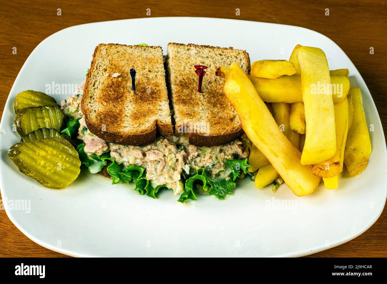 tuna salad sandwich served with steak potaoe fries and pickl;e Stock ...