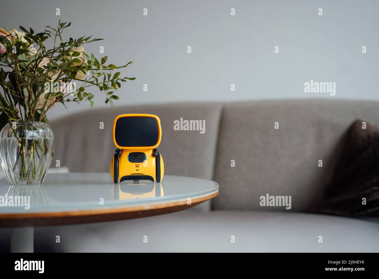Yellow AI toy robot on table in living room at home Stock Photo - Alamy