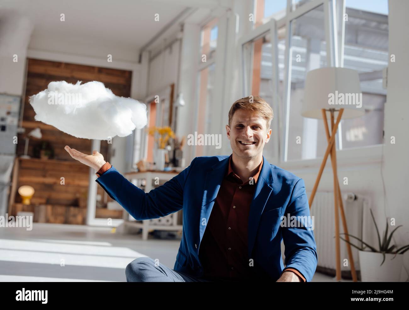 Happy businessman with levitating cloud network sitting in office Stock ...
