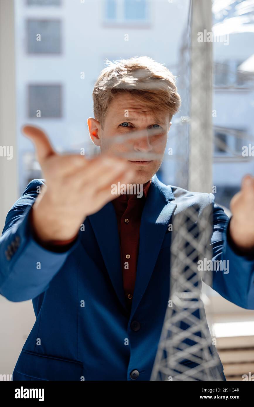 Businessman analyzing electricity pylon model standing in front of ...