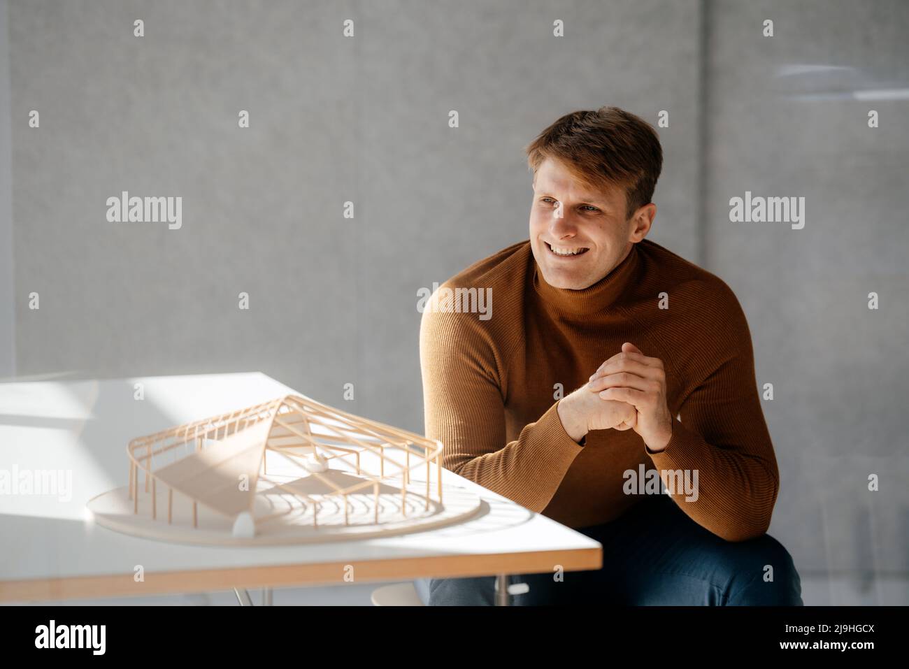 Happy architect sitting with leaf shaped model at desk in office Stock ... Happy architect sitting with leaf shaped model at desk in office Stock ...