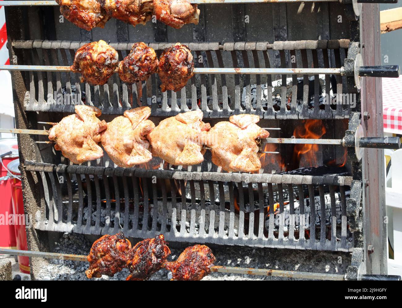large rotating spit with chickens and cockerels that are cooked slowly ...
