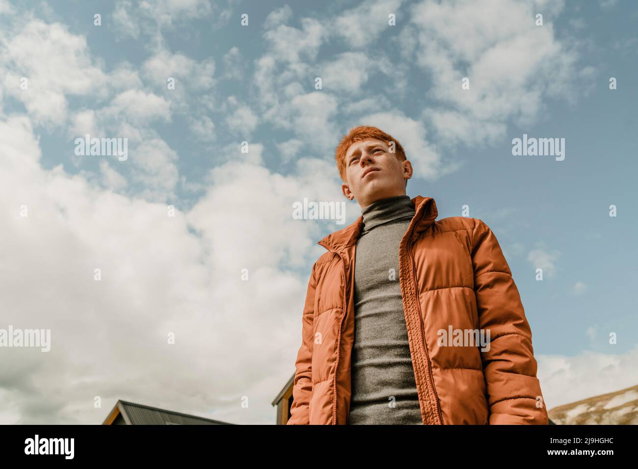 Contemplative teenage boy standing under cloudy sky Stock Photo - Alamy