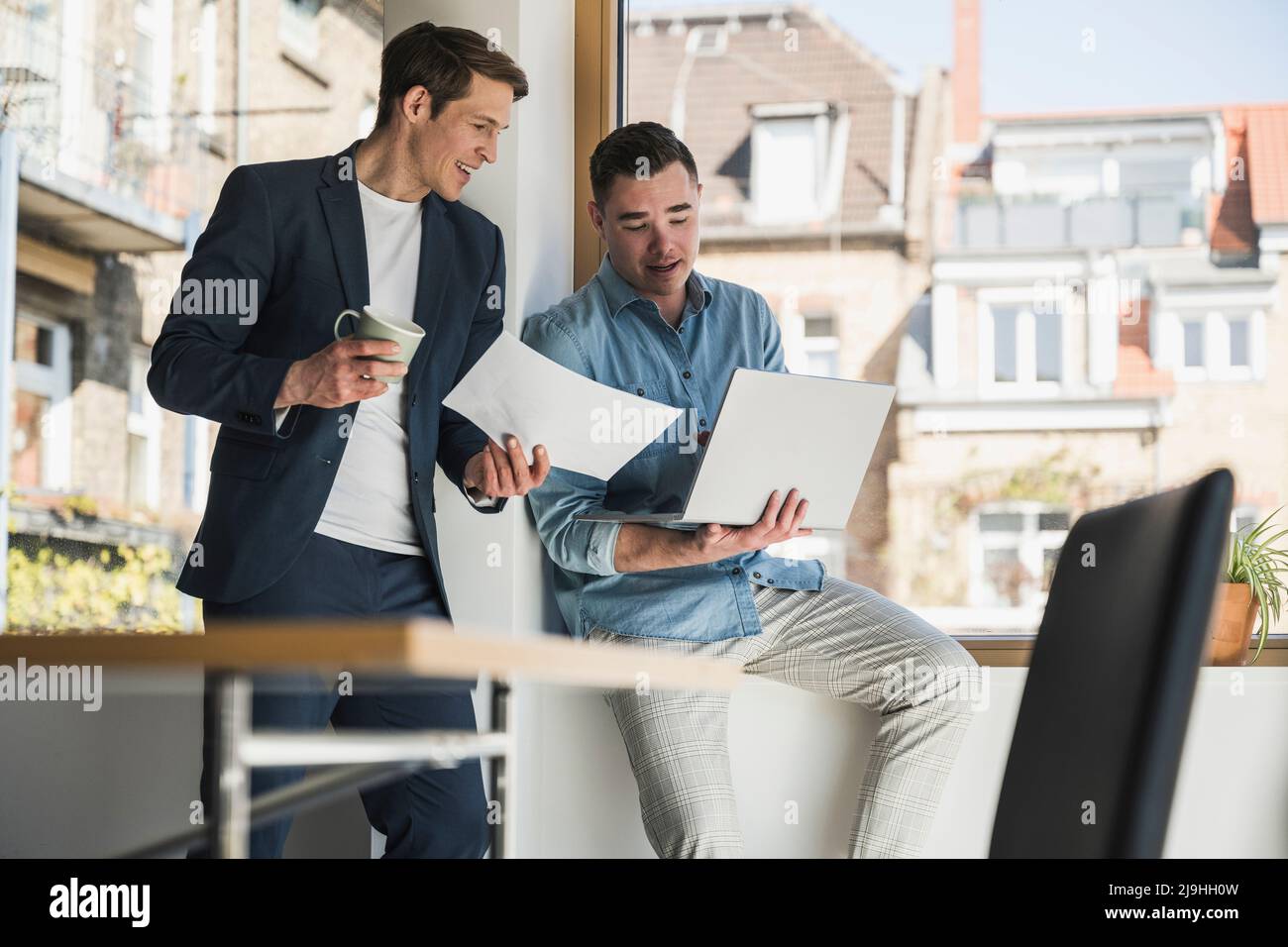 Two happy colleagues laptop hi-res stock photography and images - Alamy