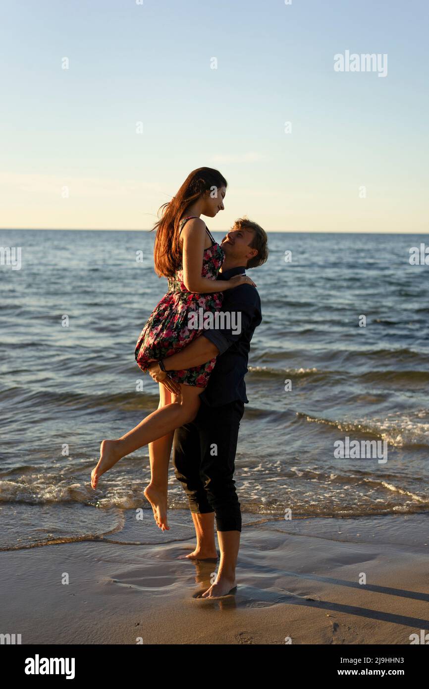 Boyfriend lifting girlfriend at beach on sunny day Stock Photo - Alamy