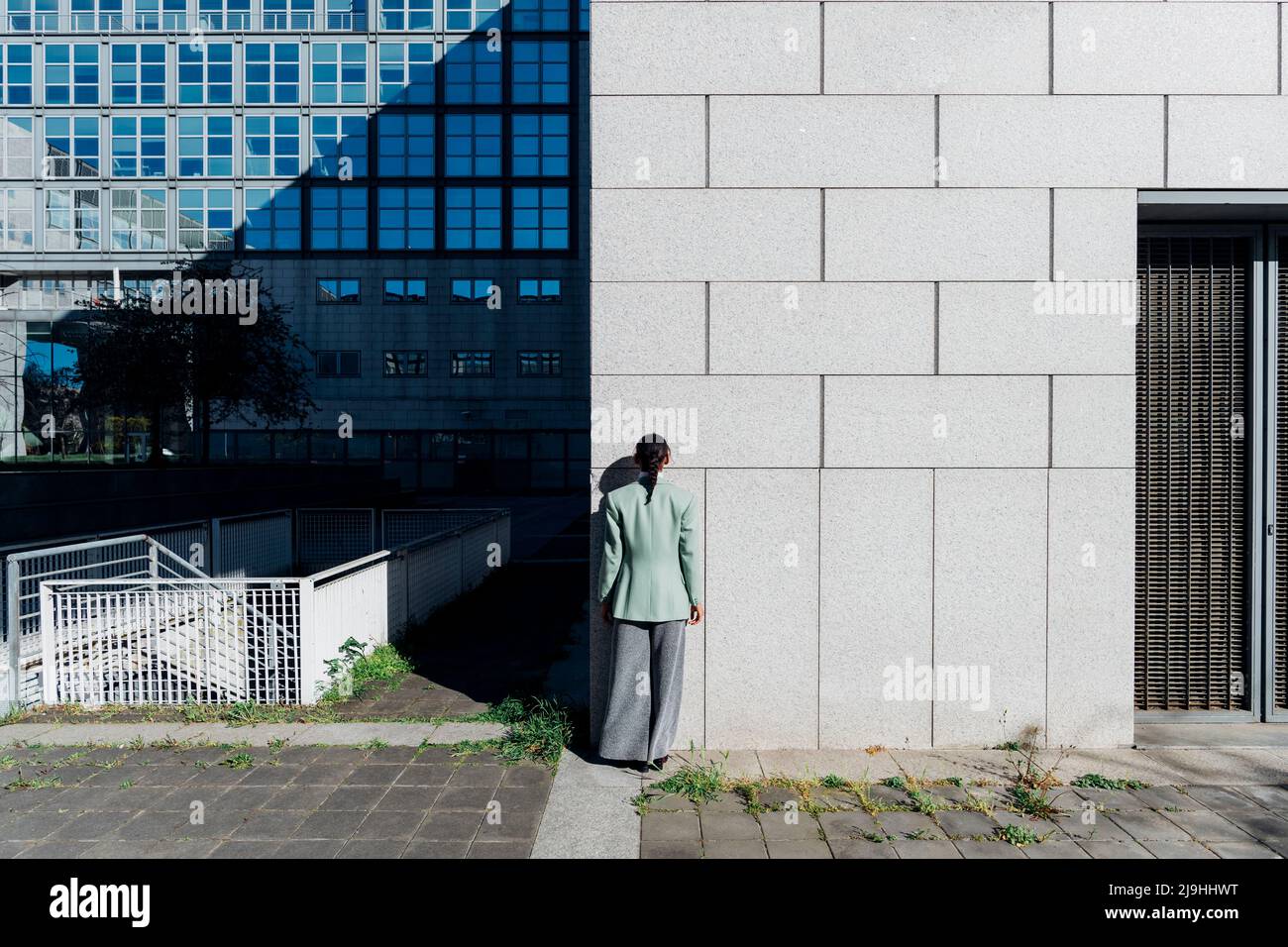 Businesswoman facing wall of office building Stock Photo - Alamy