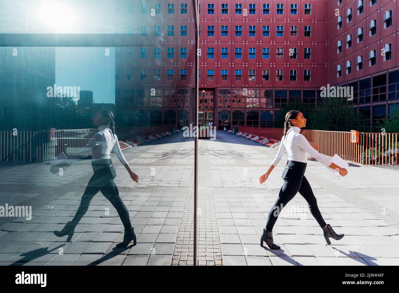 Businesswoman with paper document walking in office campus Stock Photo ...