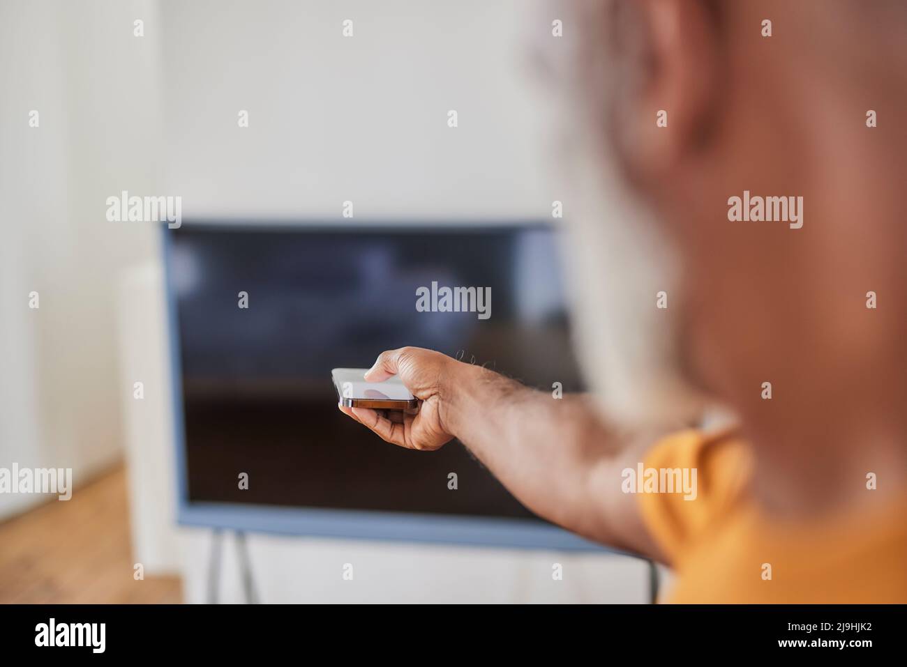 Man switching on television through smart phone at home Stock Photo - Alamy