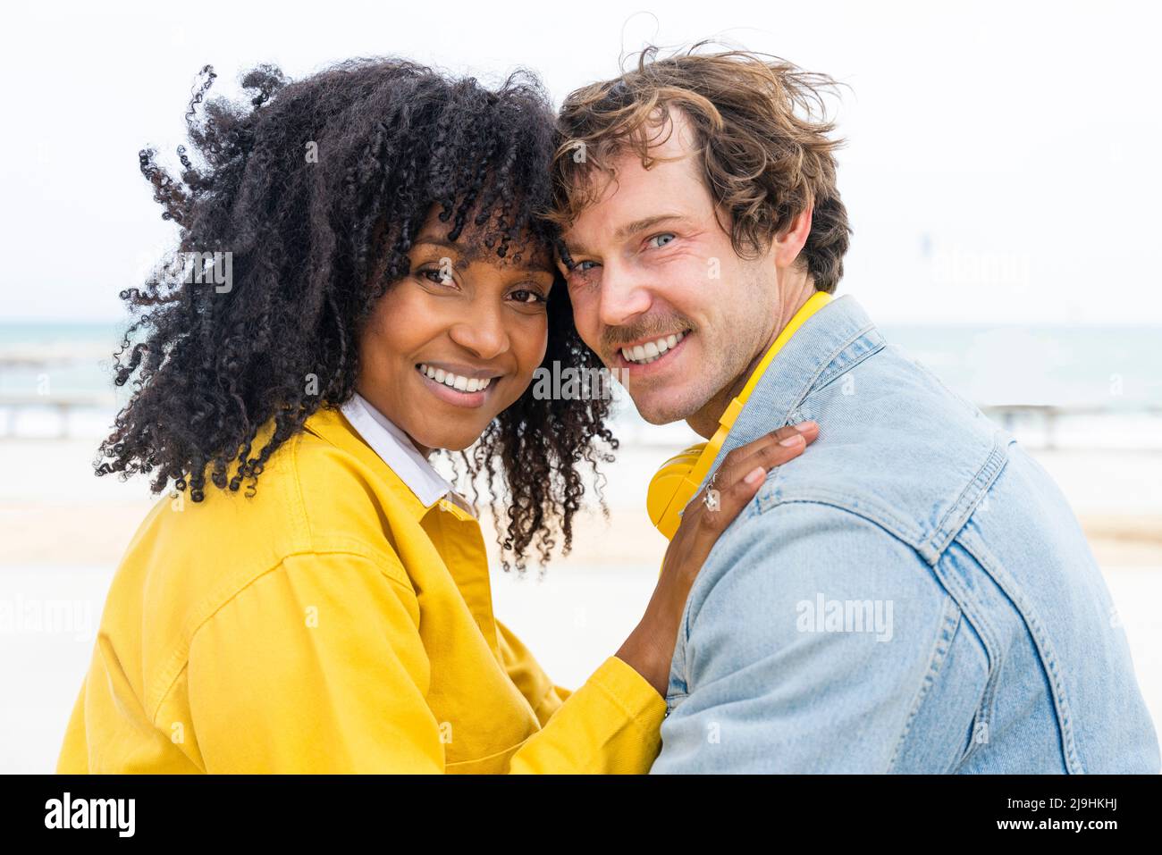 Smiling couple touching heads looking over shoulder together Stock ...