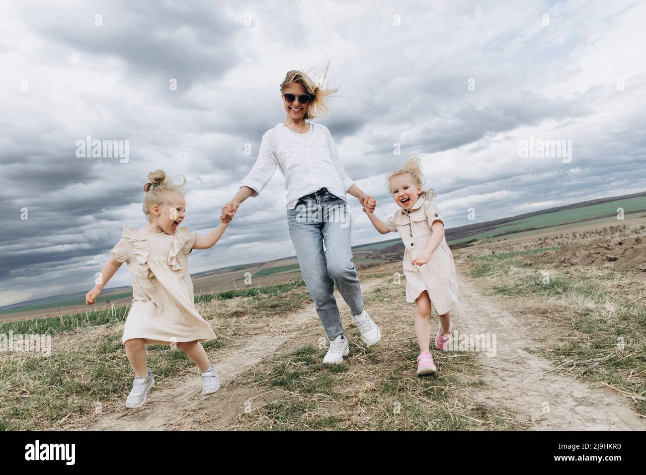 Mother running with daughters on pathway in agricultural field Stock ...